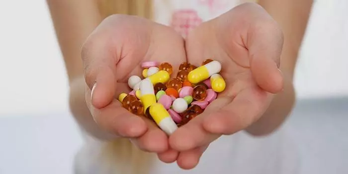 Flicka som håller piller i händerna