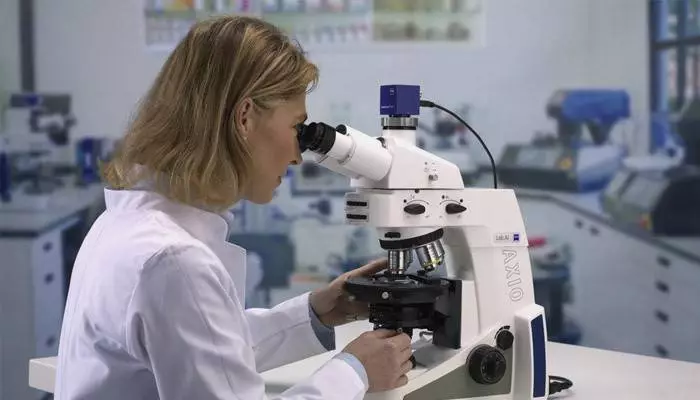 Girl examines blood under a microscope