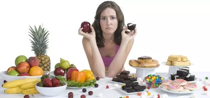 Djevojka bira između slatkiša i voća