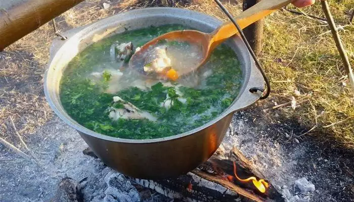 Žuvies sriubos su degtine virimo procesas ant ugnies