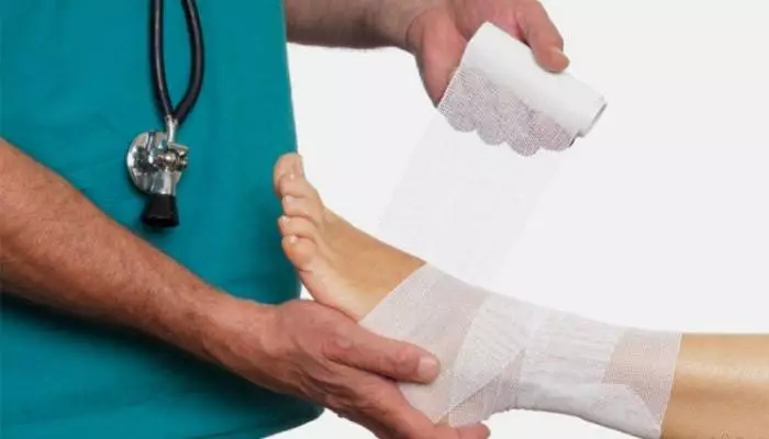 Mjeku siguron ndihmë urgjente me ndrydhjen e kyçit të këmbës