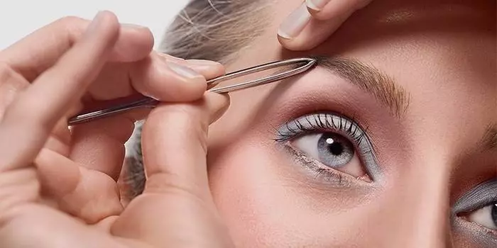 Eyebrow shaping with tweezers