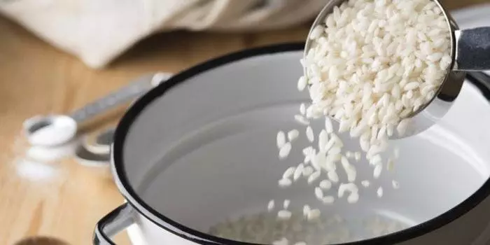चावल एक सॉस पैन में डाला जाता है