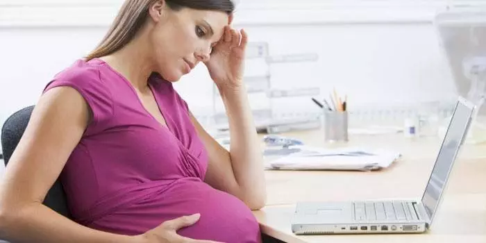 Kobieta w ciąży przy laptopie
