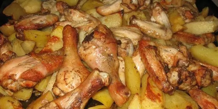 Pernas de frango com batatas em uma assadeira