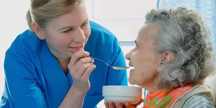 Donar de menjar a una dona gran després d’un ictus