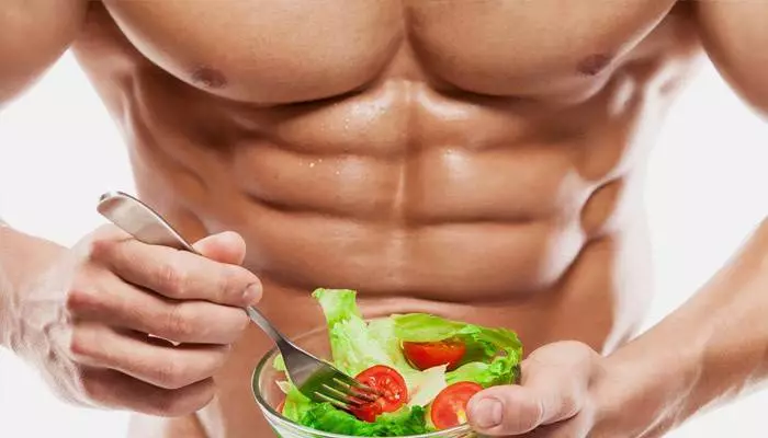 ताजा सब्जी सलाद खाते हुए पुरुष एथलीट