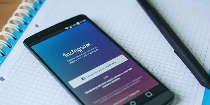 App Instagram fuq it-telefon, in-notepad u l-pinna