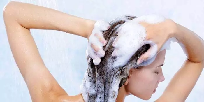 Tyttö pesee hiuksensa
