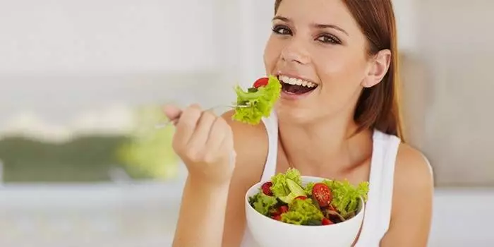 Trečią nėštumo mėnesį mergina valgo vitaminų salotas