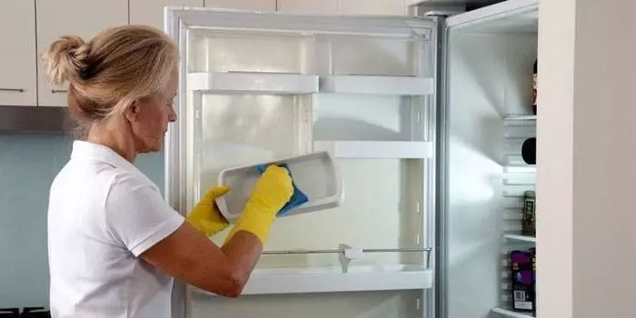 Donna che lava il frigorifero