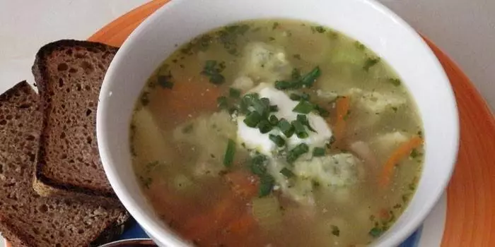 Sopa con albóndigas de ajo y crema agria en un plato