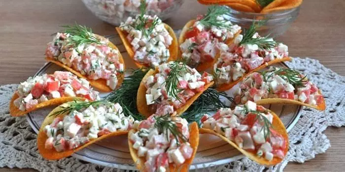 Insalata di bastoncini di granchio su patatine