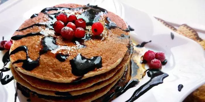 Pancakesyên amade yên bi sosê çîkolata û berûyên li ser piyalek