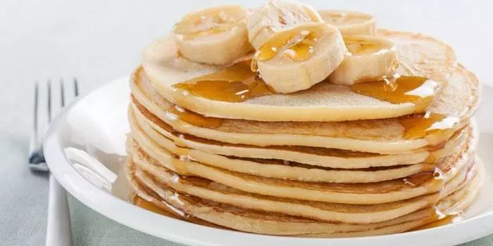 Stack of pancakes with banana and honey