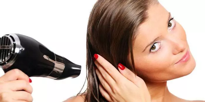 Gadis menggunakan pengering rambut