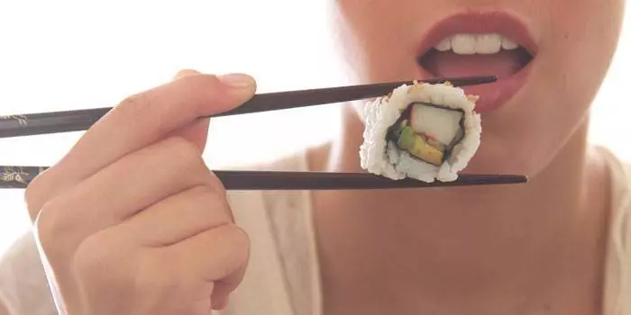 Garota comendo sushi