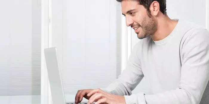Seorang lelaki yang duduk di komputer riba