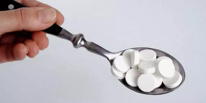 White tablets in a spoon