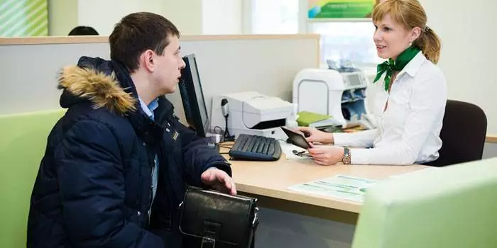 E Mann schwätzt mat engem Beroder bei der Sberbank