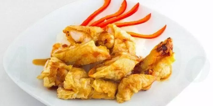 Awọn fillet adie ti a ti ge ni sisun lori batter lori awo kan