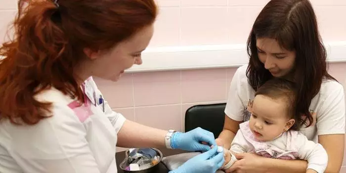 La enfermera toma la sangre del niño para analizarla.