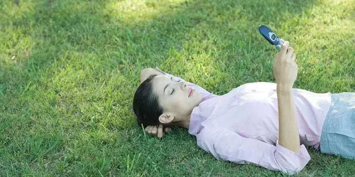 Girl lying on the grass with a phone