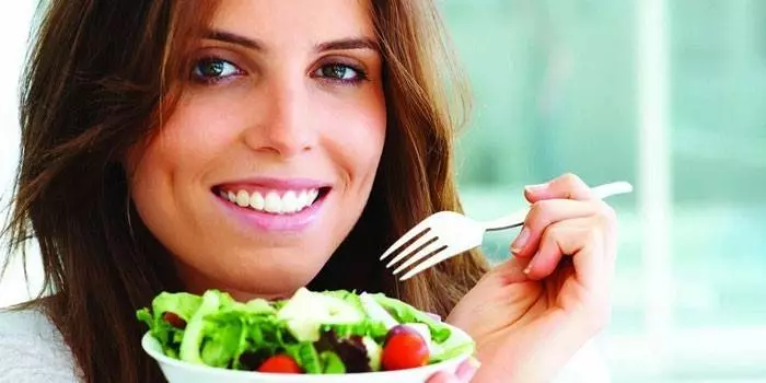 Djevojka drži tanjir salate
