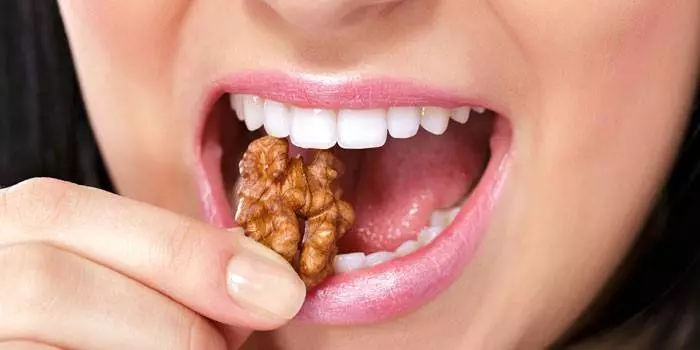 Dievča jesť orechy