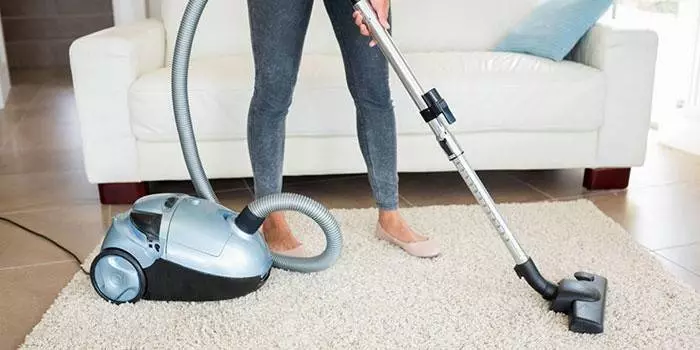 Girl vacuuming the carpet