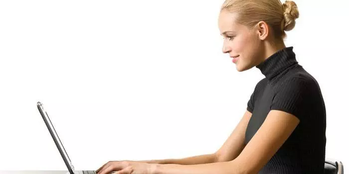 En pige, der sidder ved en bærbar computer