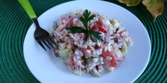 Salade de tomates avec riz et saucisse fumée