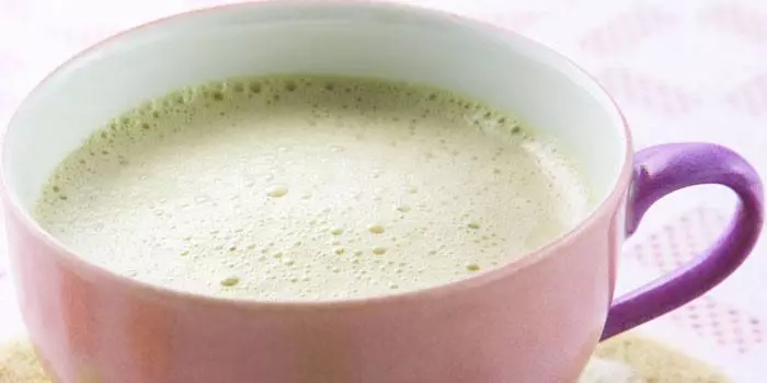 Grönt mjölk te och honung i en kopp