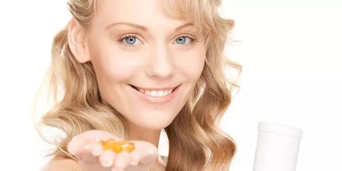 Girl holding capsules in the palm of her hand