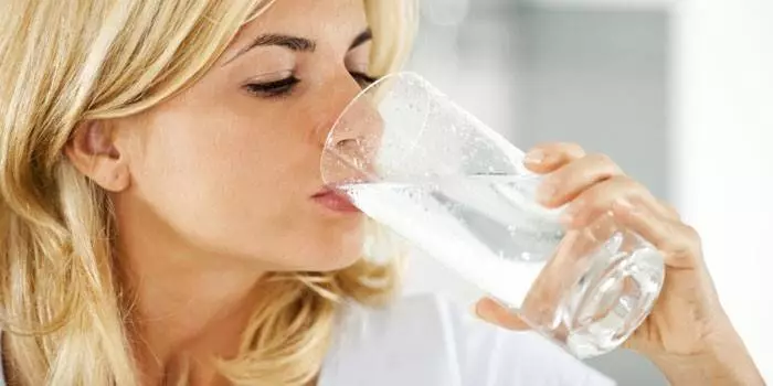 Girl drinks water from a glass