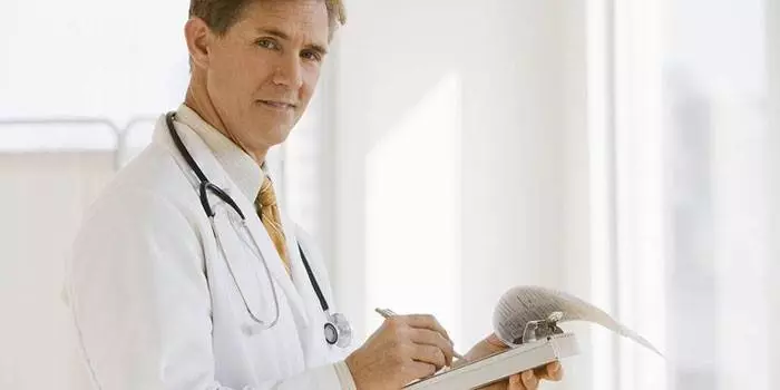 Doctor makes a note in a notebook