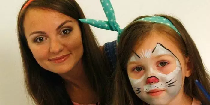 Yüz boyama kedileri ve annesi olan kız