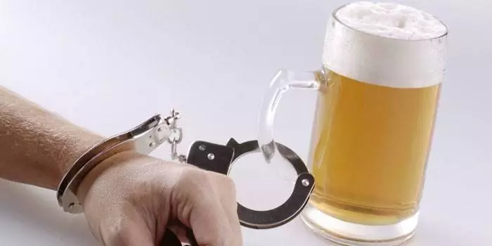 Glass of beer handcuffed to hand