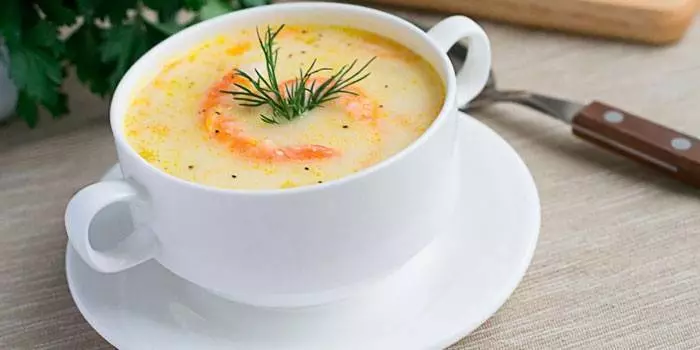Un piatto di zuppa di formaggio con gamberi