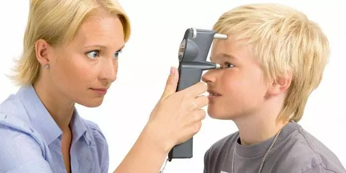 A doctor measures a boy's eye pressure