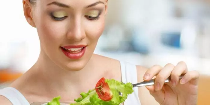 Mergaitė valgo salotas