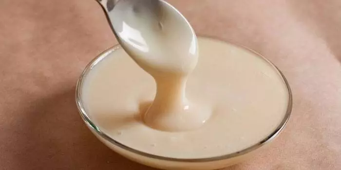 Gecondenseerde melk in lepel en sok