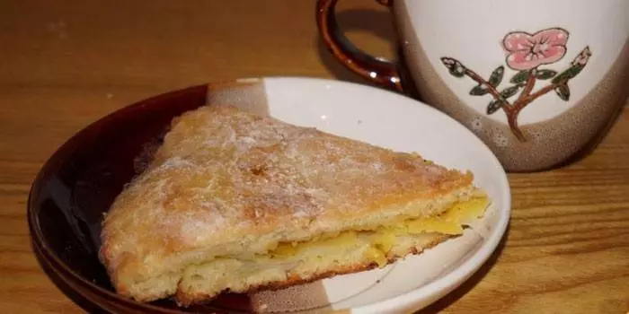 Una rebanada de pastel relleno de patatas y cebollas.