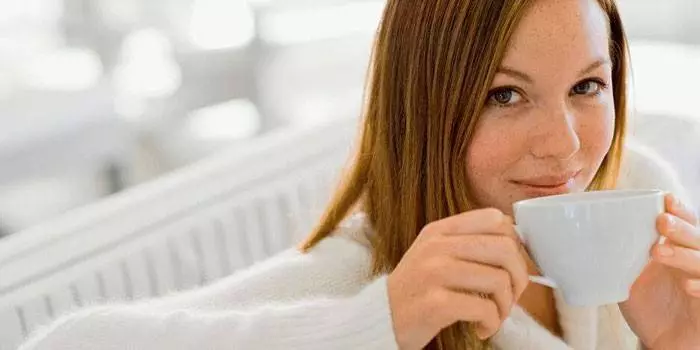 Rapaza beber té dunha cunca