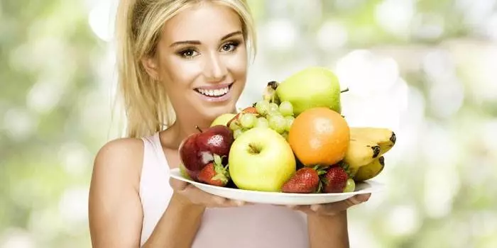 Meisje met een schotel met fruit en bessen