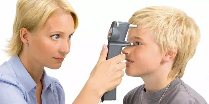 Woman measures eye pressure to a child