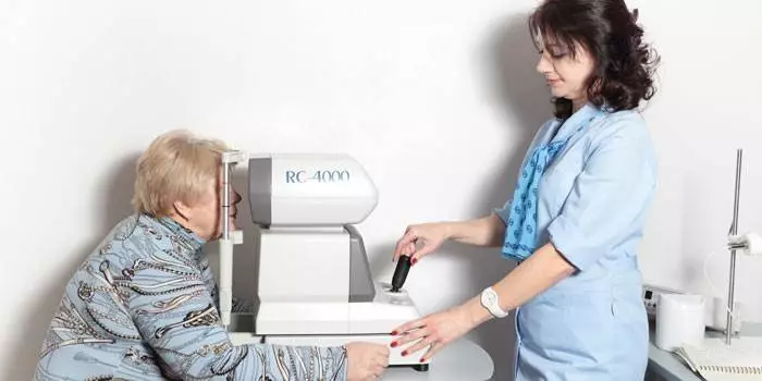 The paramedic measures the woman's eye pressure