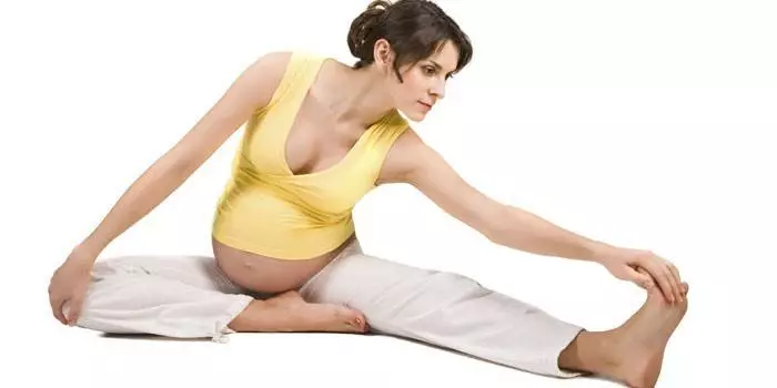 Schwangere famke docht stretching -oefening