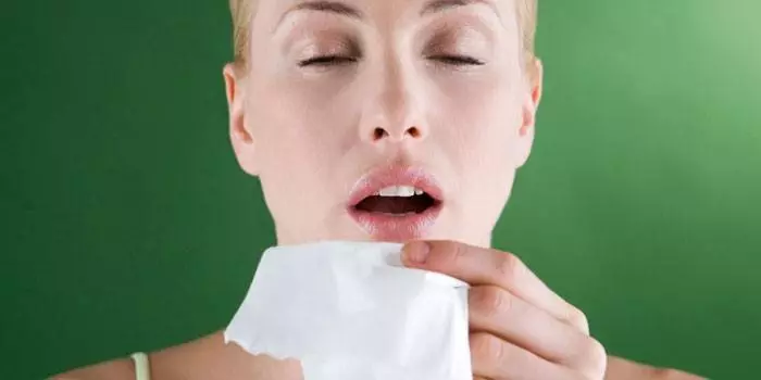 Woman sneezes