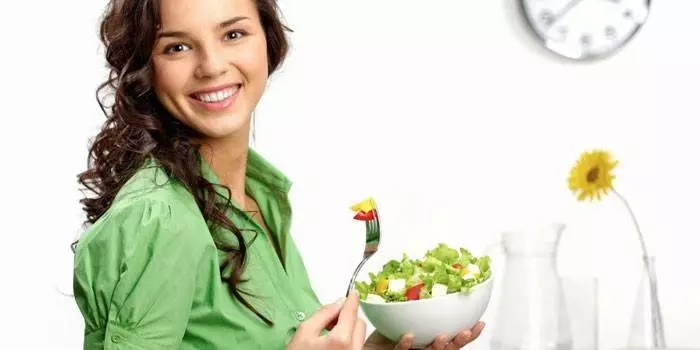 Cô gái cầm một đĩa salad